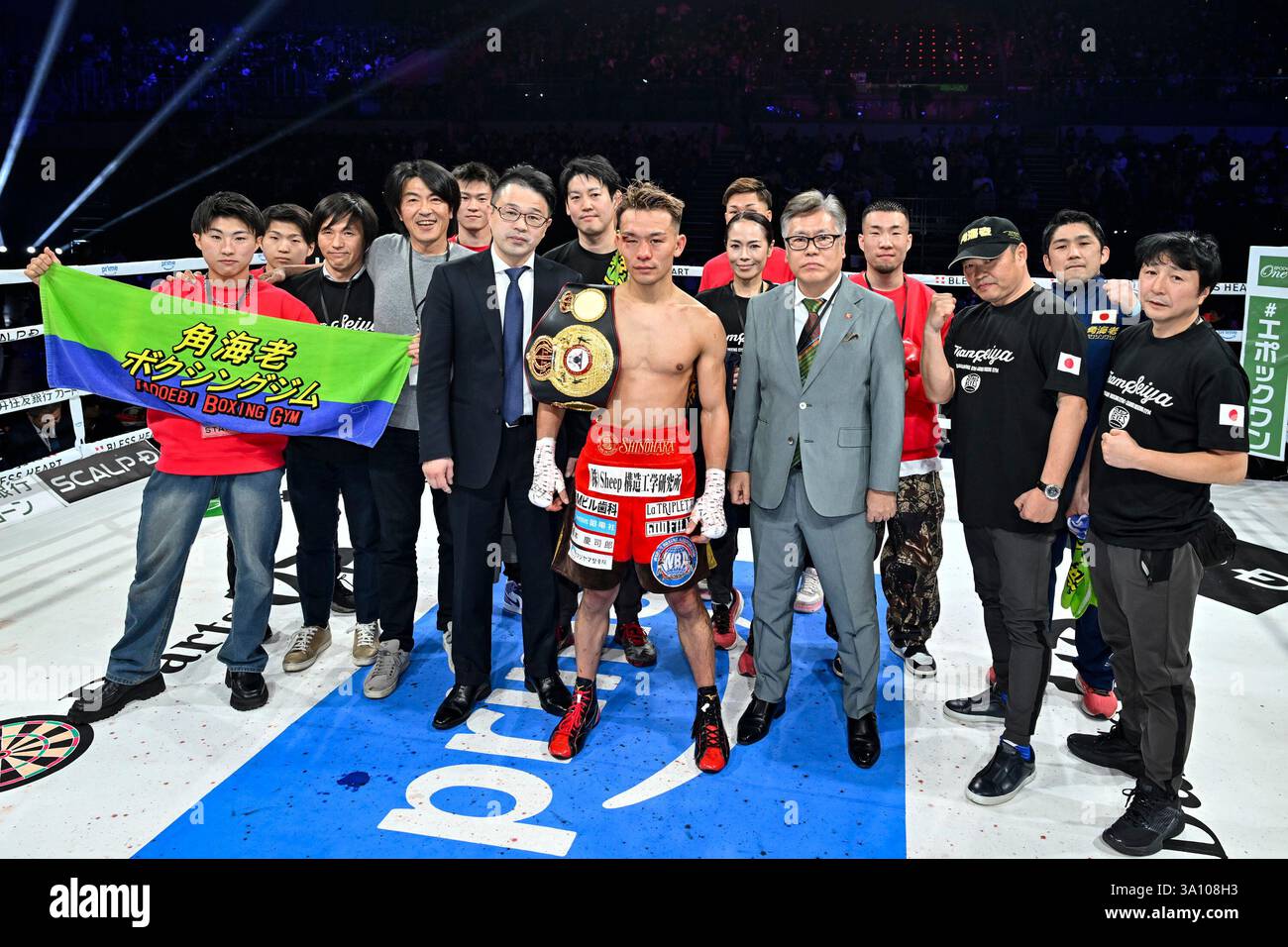 Champion Japan's Seiya Tsutsumi, center, poses with his team staff after defending his WBA ...