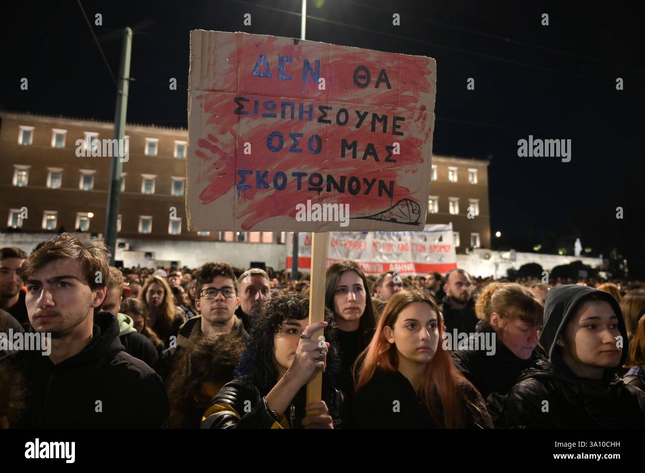 Athens, Greece, 5 March 2025. A demonstrator holds a banner that reads ...