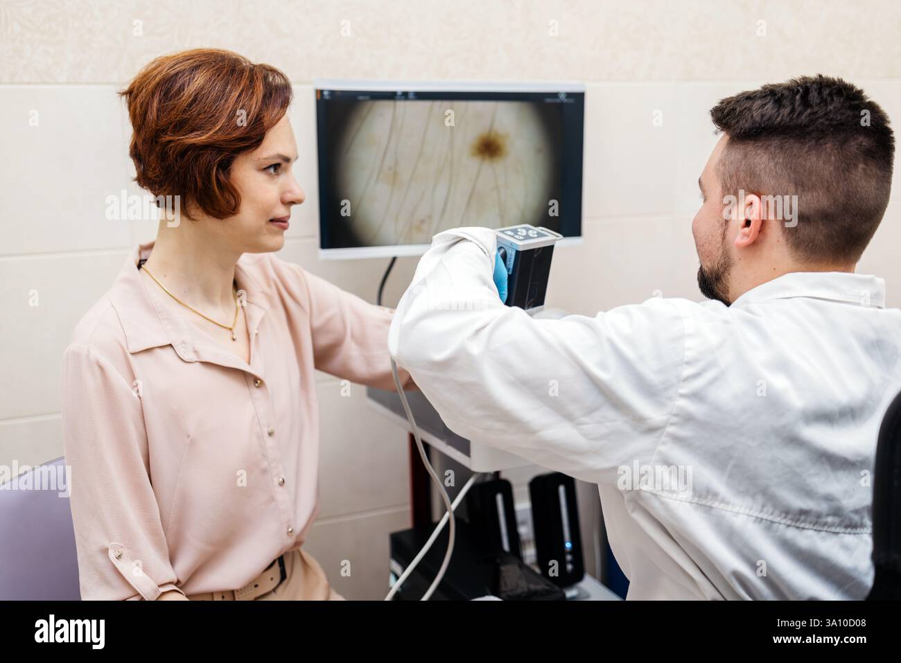 A dermatologist examines and analyzes the skin of a young patient in a ...