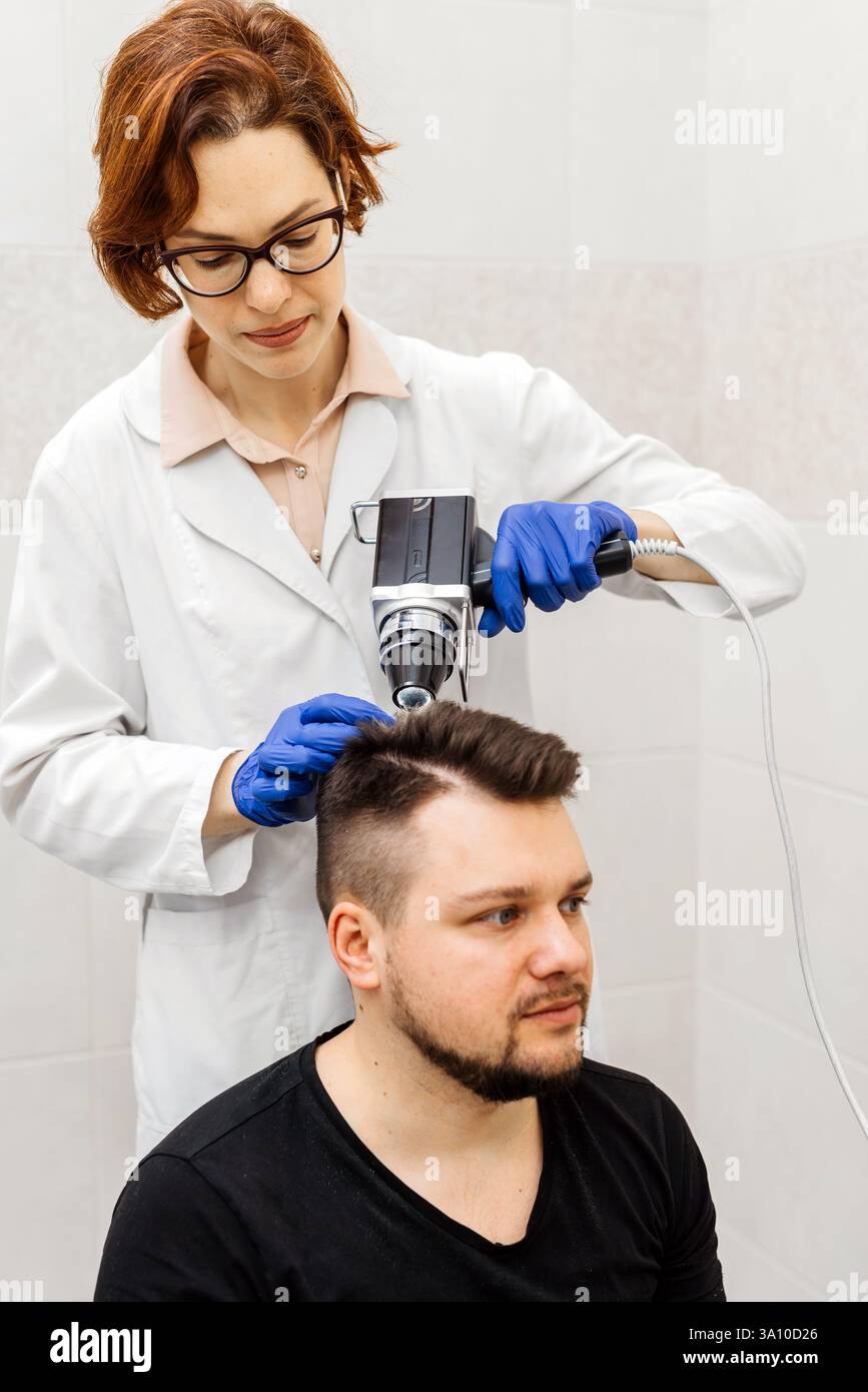 Trichoscopy of hair and scalp closeup. Trichoscope in the hands of a ...