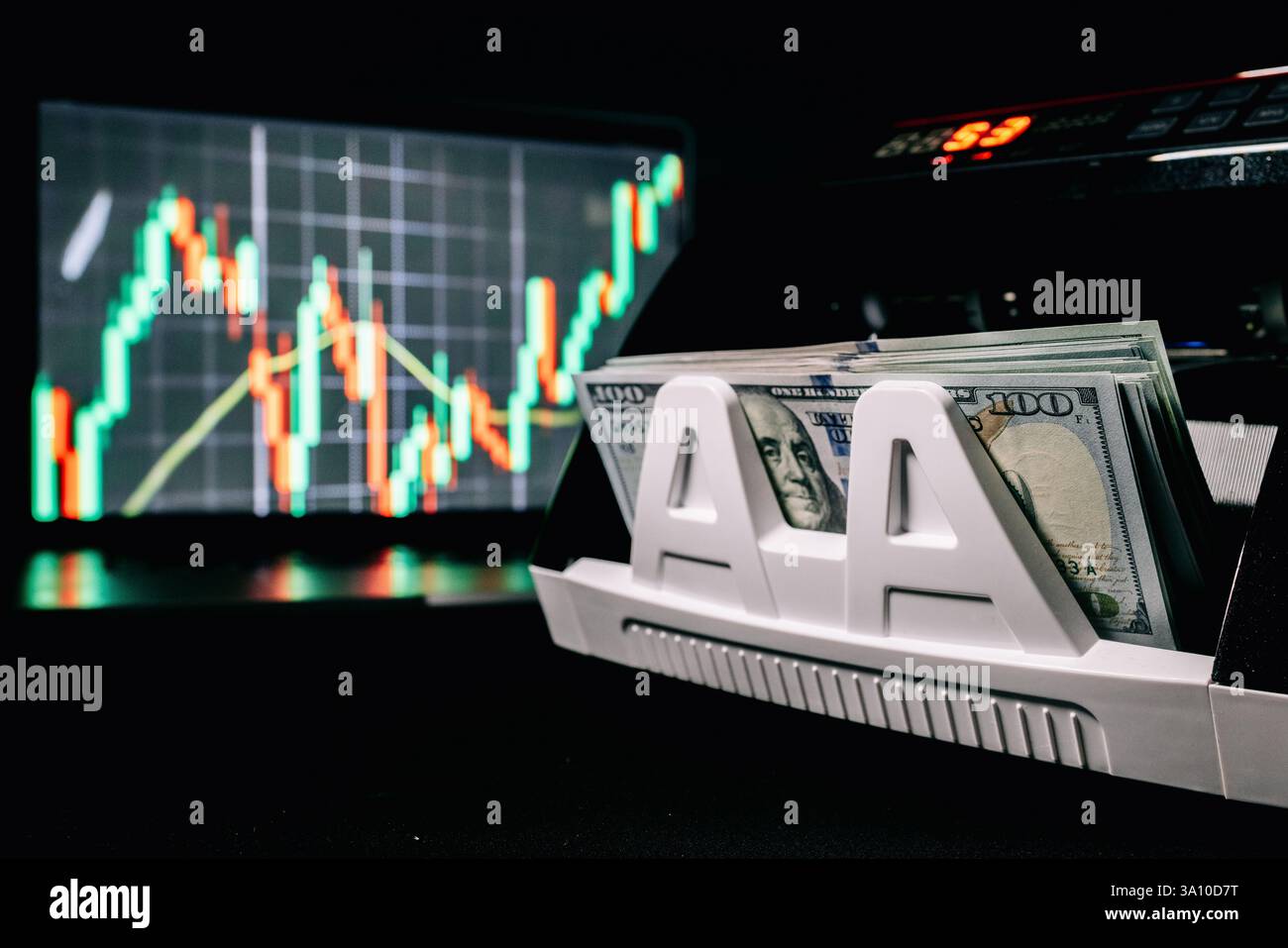 Counting US banknotes against a financial chart. Modern banking device ...