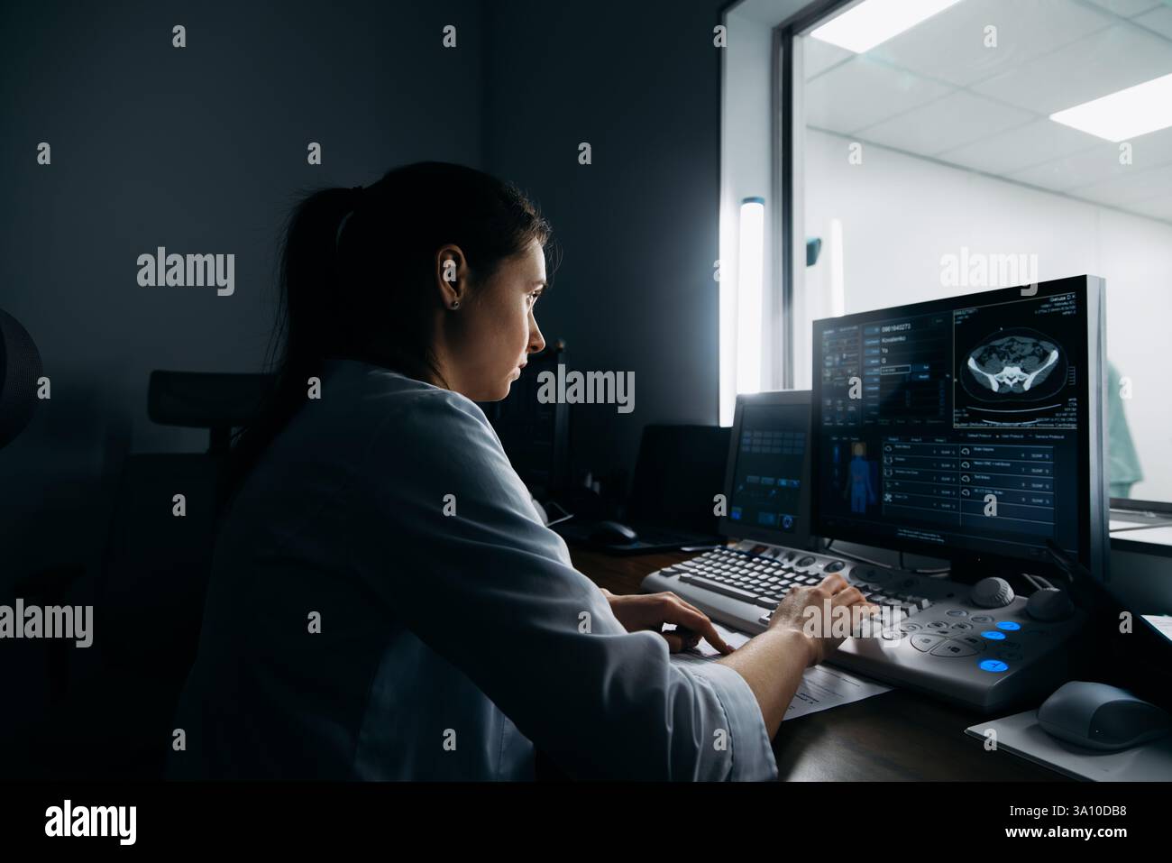 A doctor reviews X-ray images in the MRI control room while monitoring ...