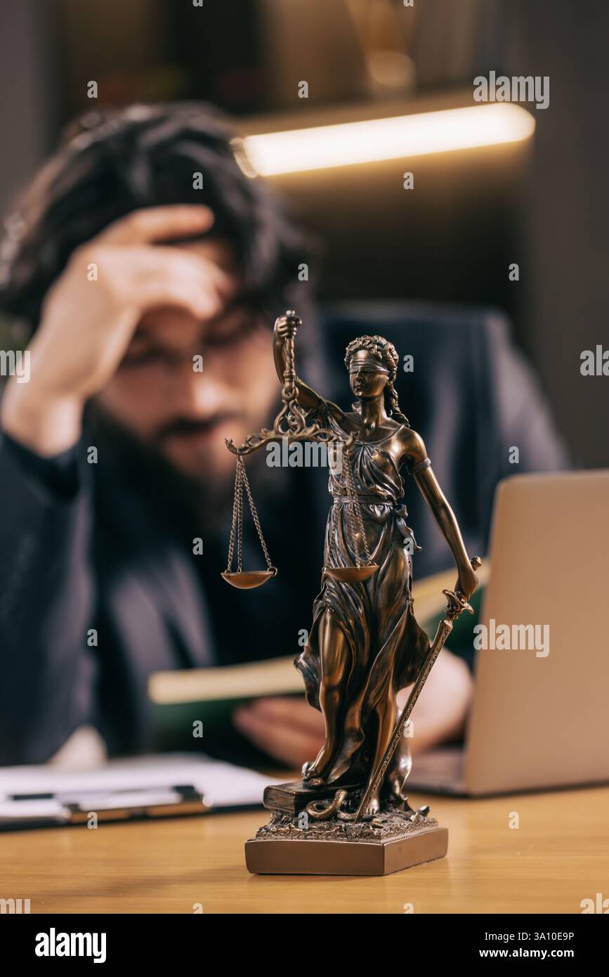 Statue of Justice with scales and a lawyer working on a laptop. Concept ...