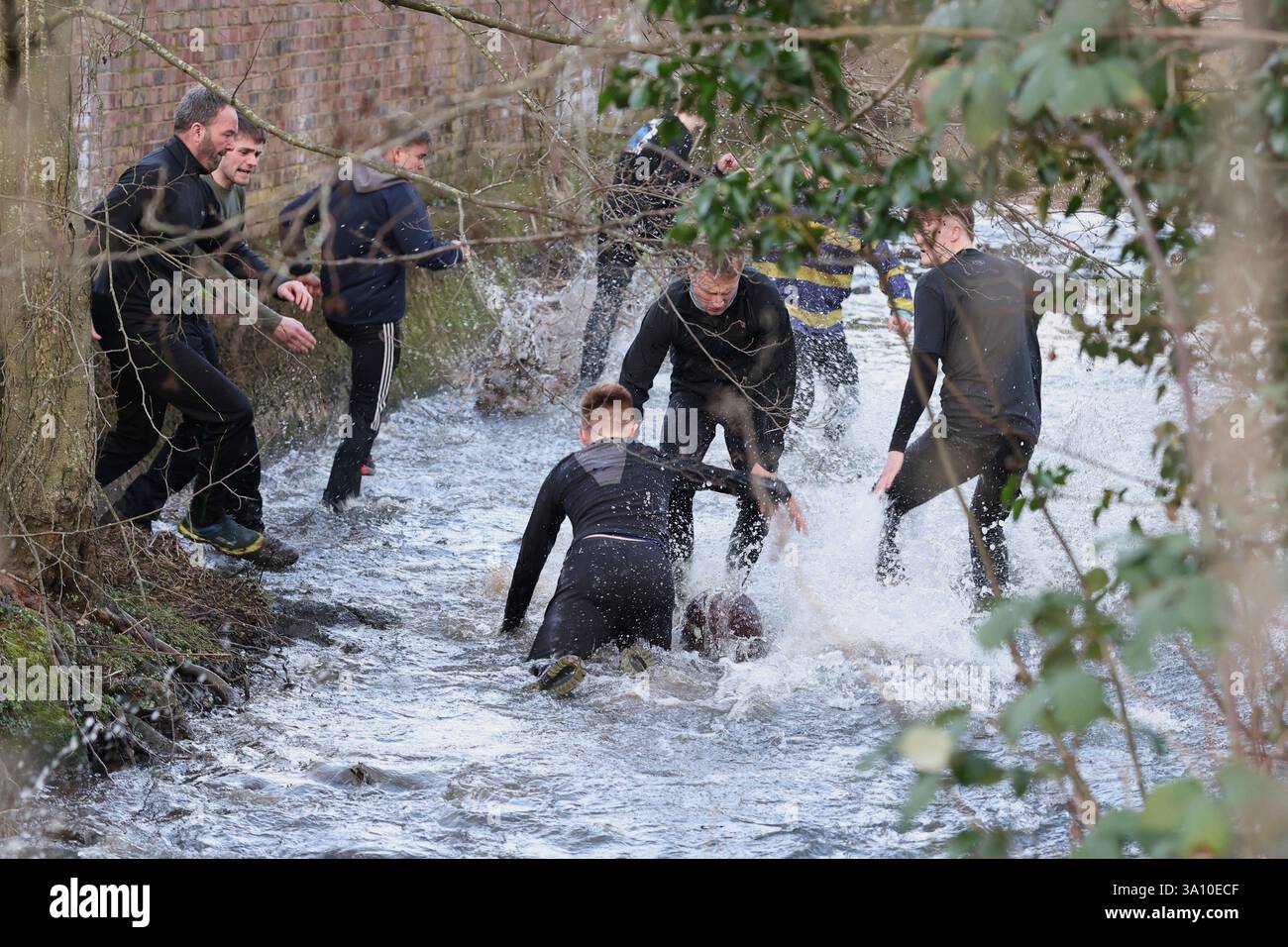 Players try to grab the ball from the Henmore Brook during the annual ...