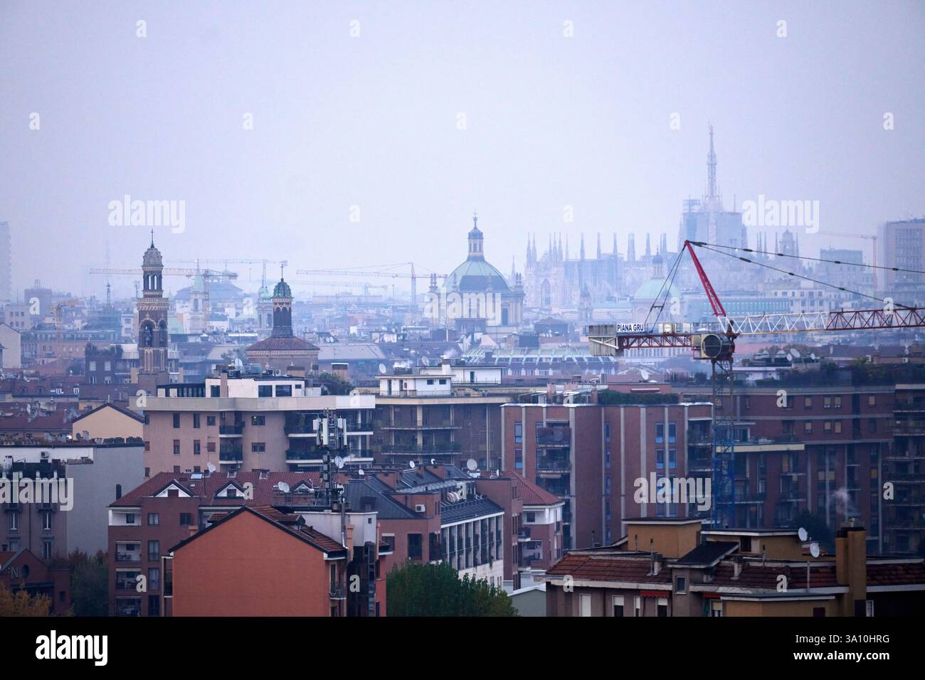 A cityscape with red buildings, skyscrapers, and a construction crane ...
