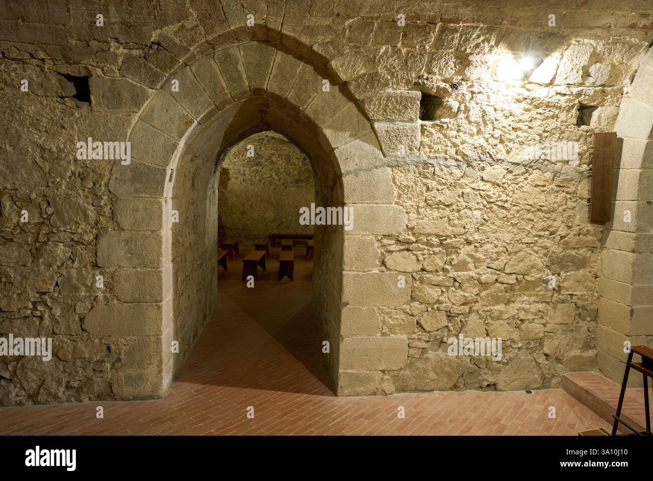 Historic stone archway leading to a dimly lit medieval room with ...