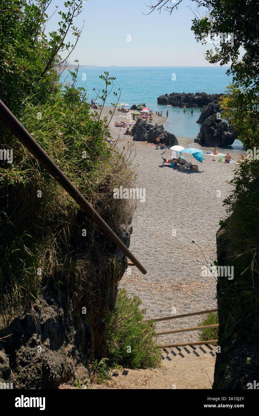 A pathway to a sandy beach with swimmers in the ocean Stock Photo - Alamy