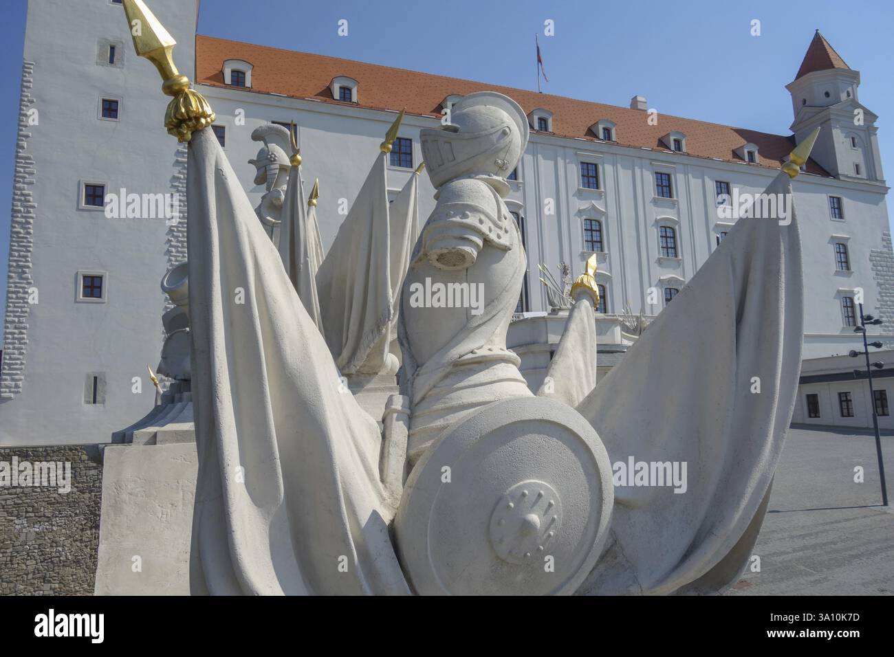 Sculpture in armour with flags in front of a majestic castle building ...