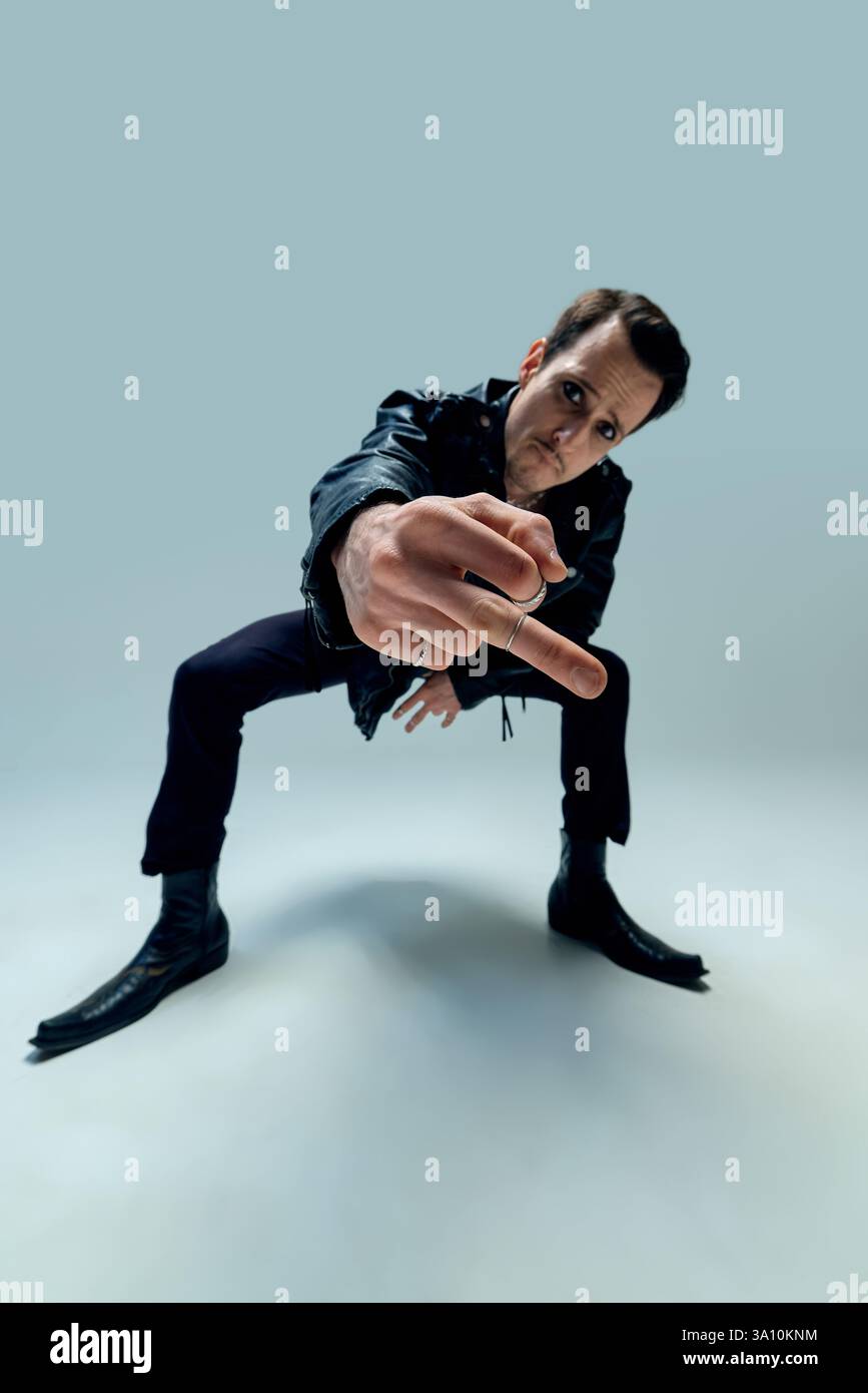 Bold artist making rebellious gesture with intense presence and fierce ...