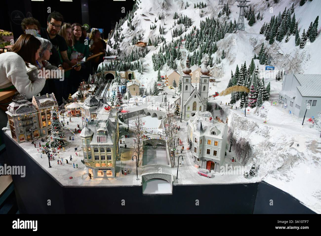 Several tourists stand in front of a snowy mountain at Mini World Lyon ...
