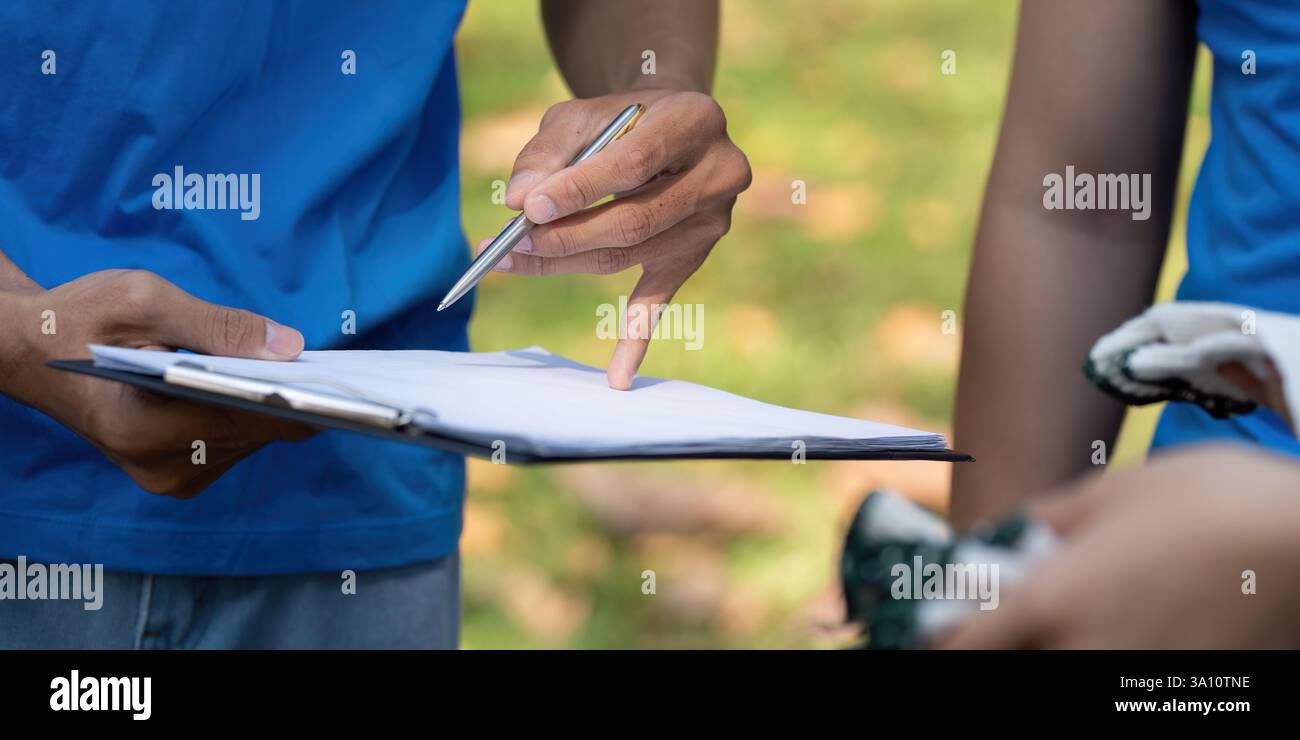 Volunteers discussing plans during a community clean-up event ...