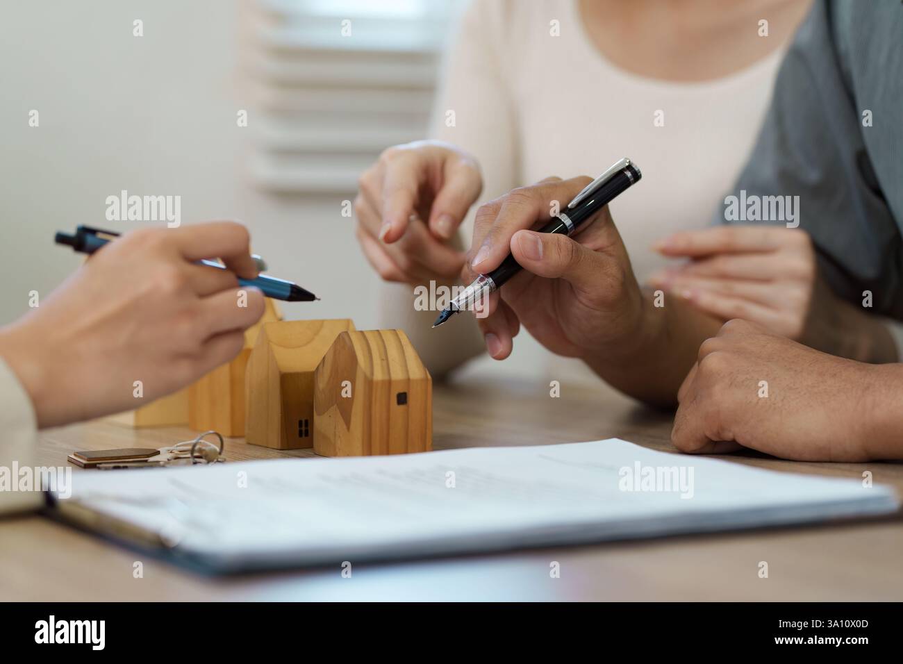 Clients discussing property details and signing a contract with a real ...