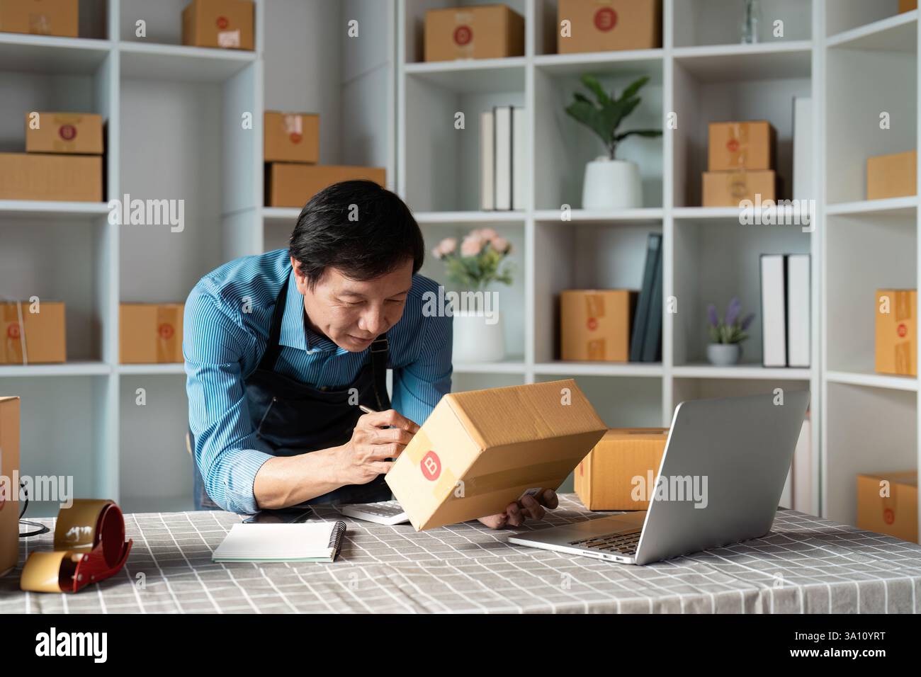 Entrepreneur managing inventory and packing orders in a modern office ...