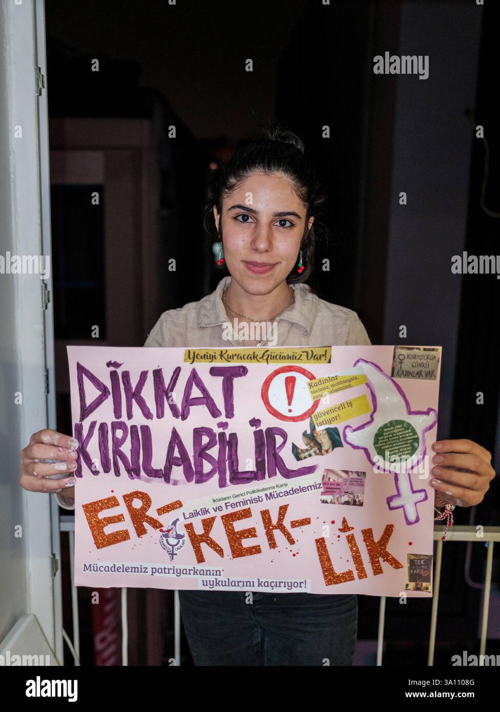 A woman poses with a banner she made herself. Feminist women organized ...