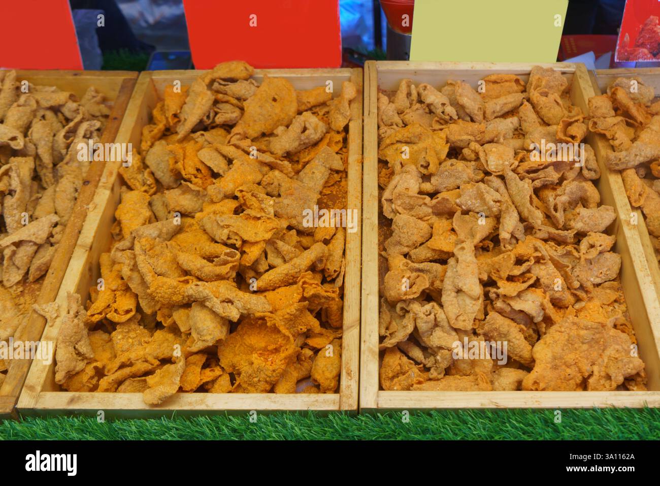 close-up shot of seasoned Chicken Skin cracklings on display in wooden ...