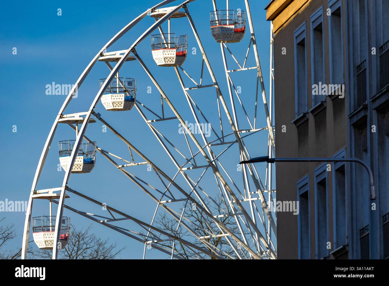 Amusement park in the city center, large ferris wheel, tall carousel ...