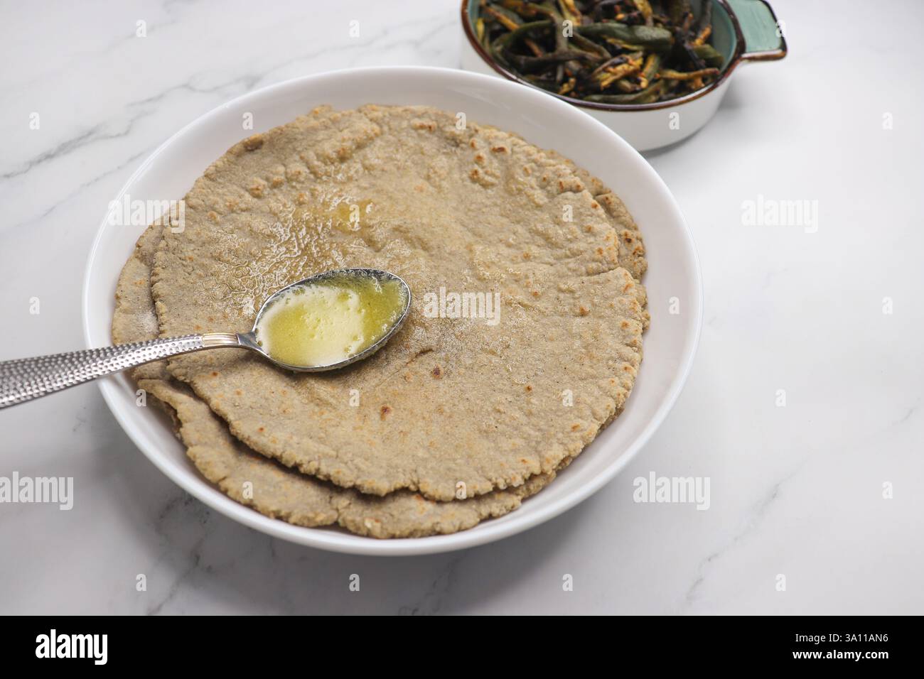 Jowar flour flatbread known as bhakar or jawari bhakri. served with ...