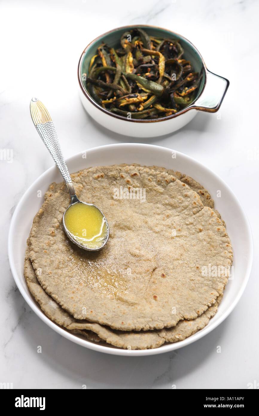 Jowar flour flatbread known as bhakar or jawari bhakri. served with ...
