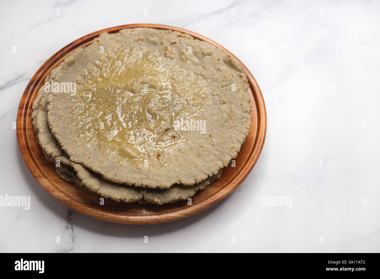 Jowar flour flatbread known as bhakar or jawari bhakri. served with ...
