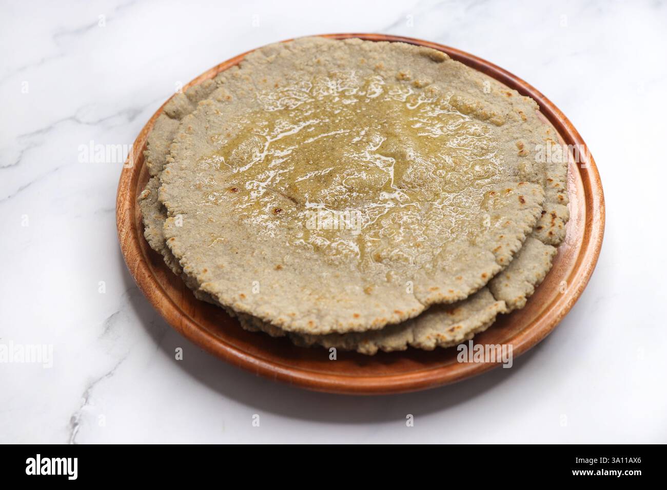 Jowar flour flatbread known as bhakar or jawari bhakri. served with ...