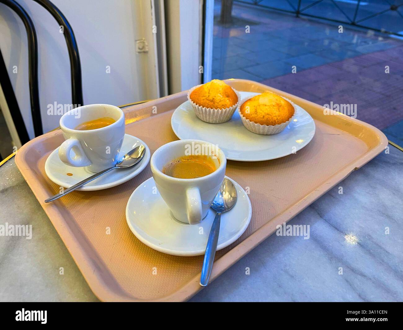 Two cups of coffee with two muffins in a cafeteria Stock Photo - Alamy
