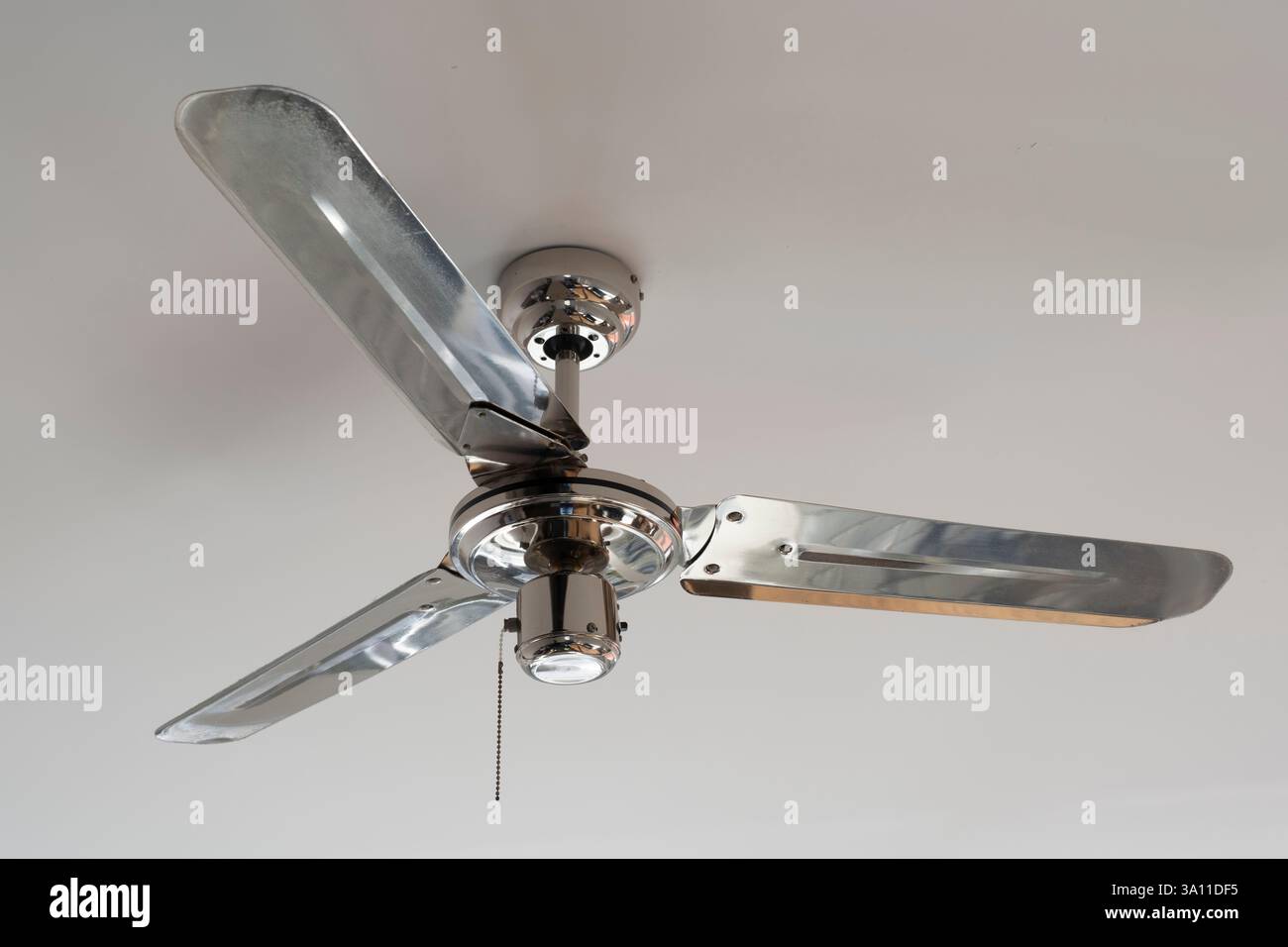 Shiny ceiling fan on light gray background. Seen from below Stock Photo ...