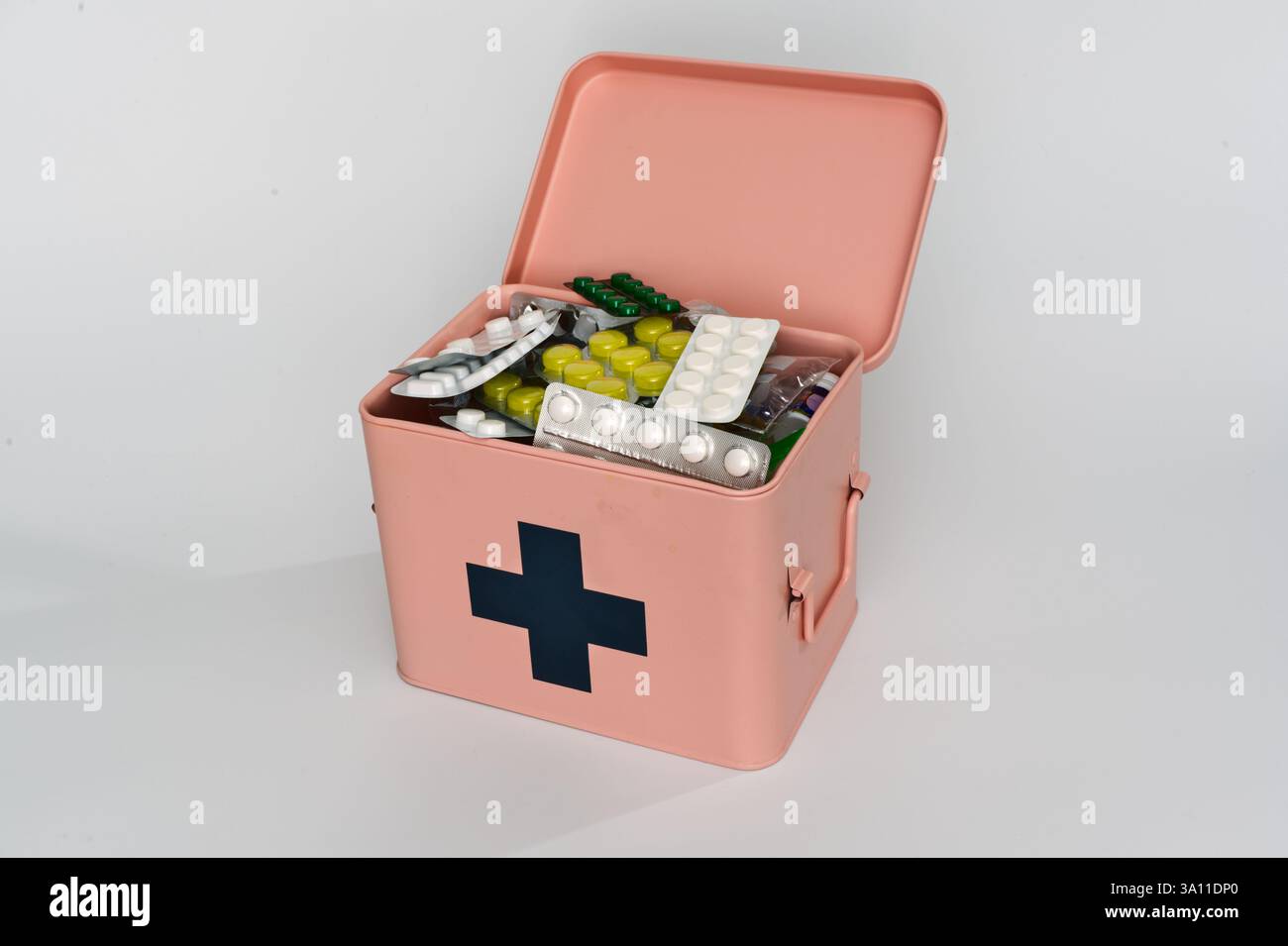 A pink first aid box with a black cross is open, revealing various ...