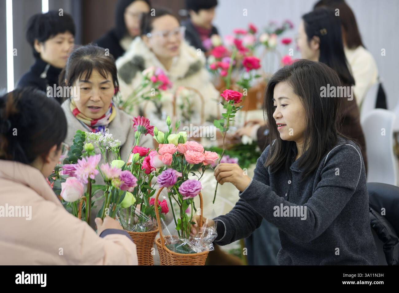 Huzhou, China's Zhejiang Province. 5th Mar, 2025. Women learn flower arrangement during an event ...
