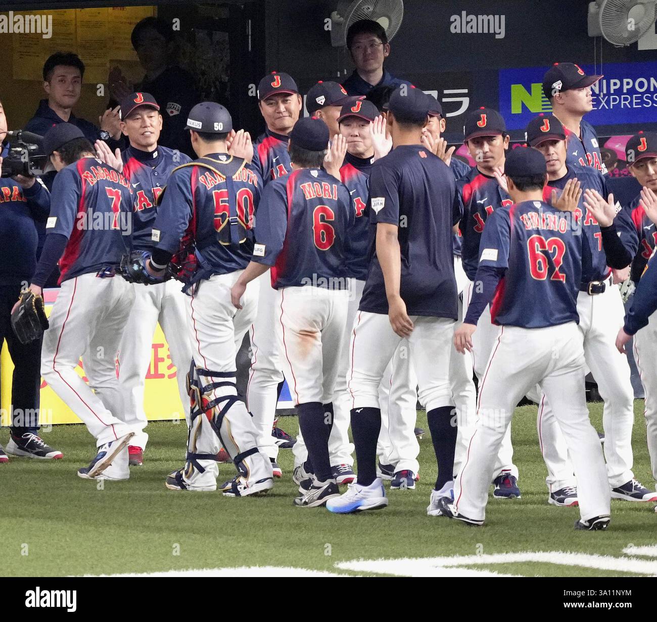 Japan manager Hirokazu Ibata (back, far L) and players high-five each ...