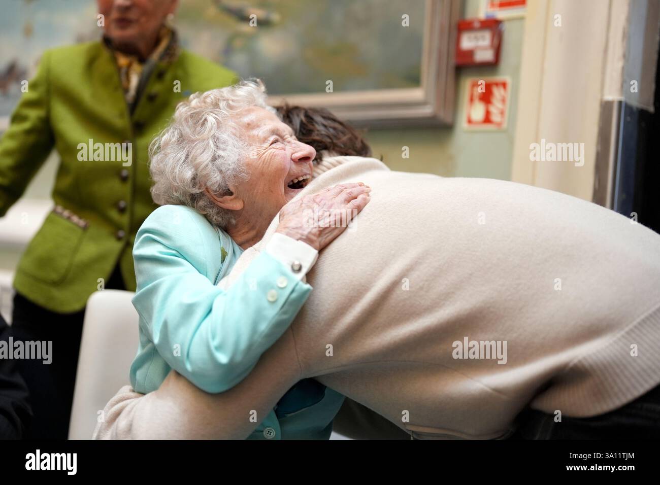 WWII veteran Dorothea Barron hugs a guest during an International Women ...