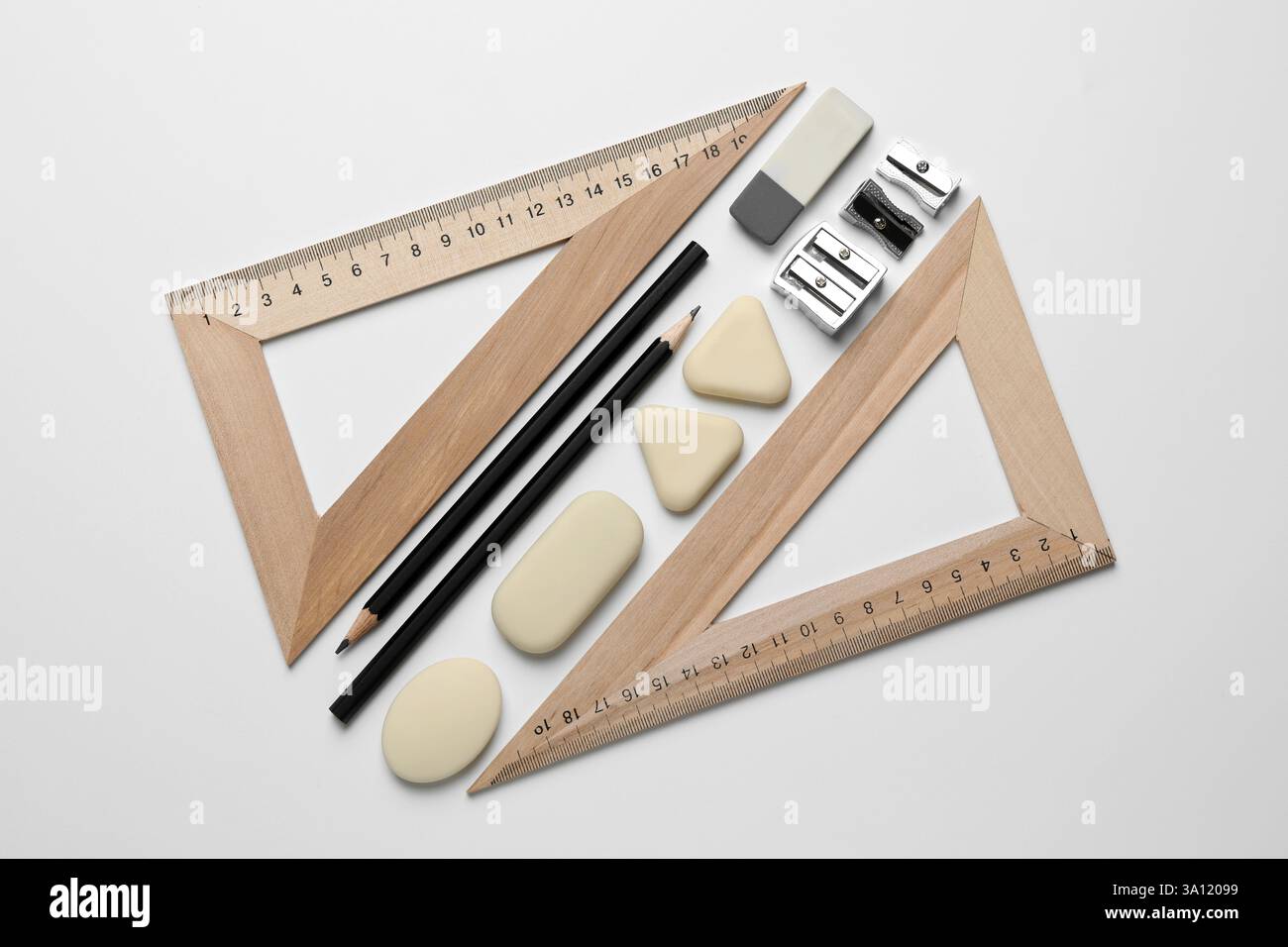 Erasers, pencils, triangle rulers and sharpeners on white background ...