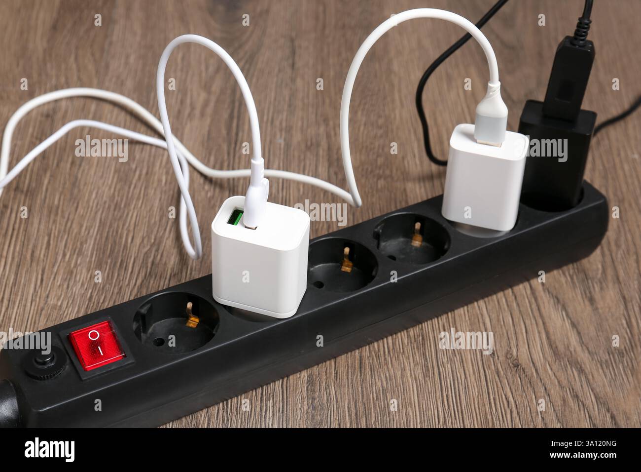 USB adapters with charge cables in power strip on floor, closeup Stock ...
