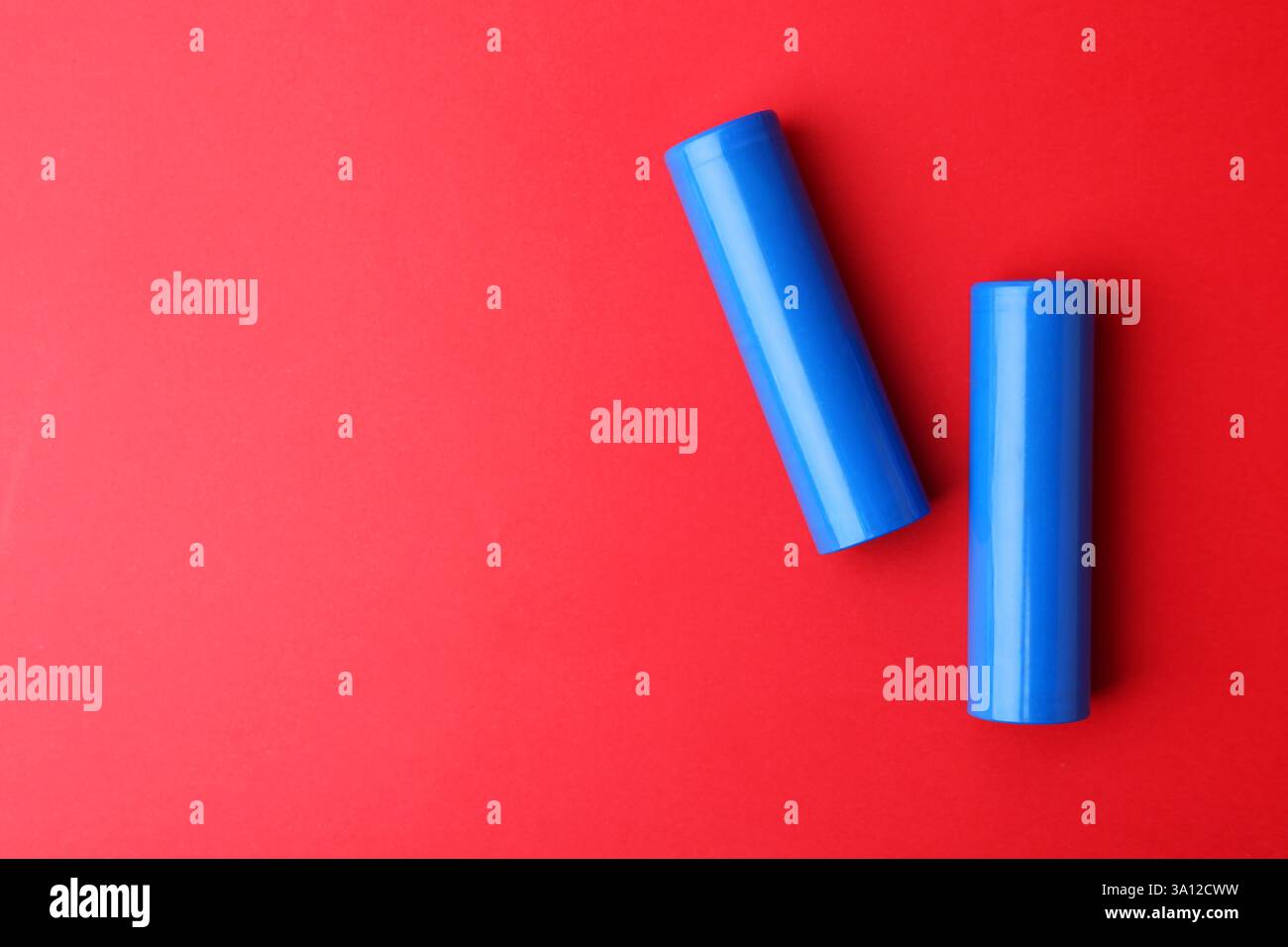 Two AA cell batteries on red background, top view. Space for text Stock ...