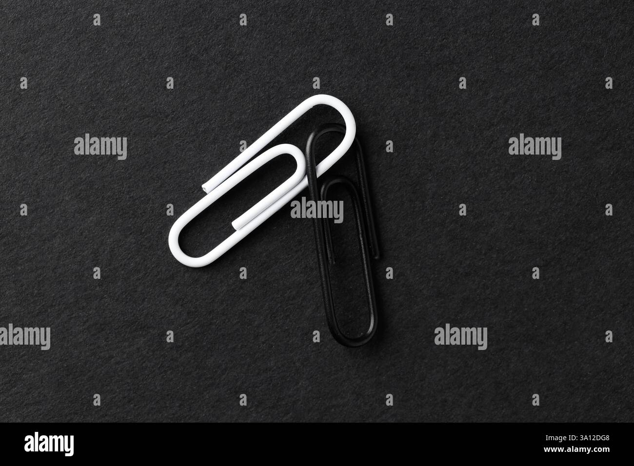Two paper clips on black background, top view Stock Photo - Alamy