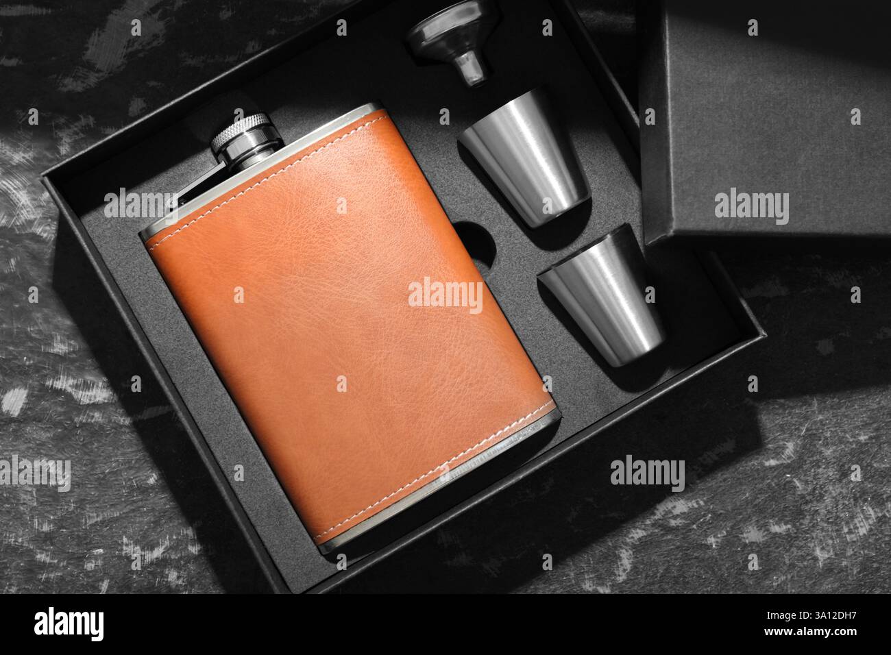 Hip flask, cups and funnel in package on dark table, top view Stock ...