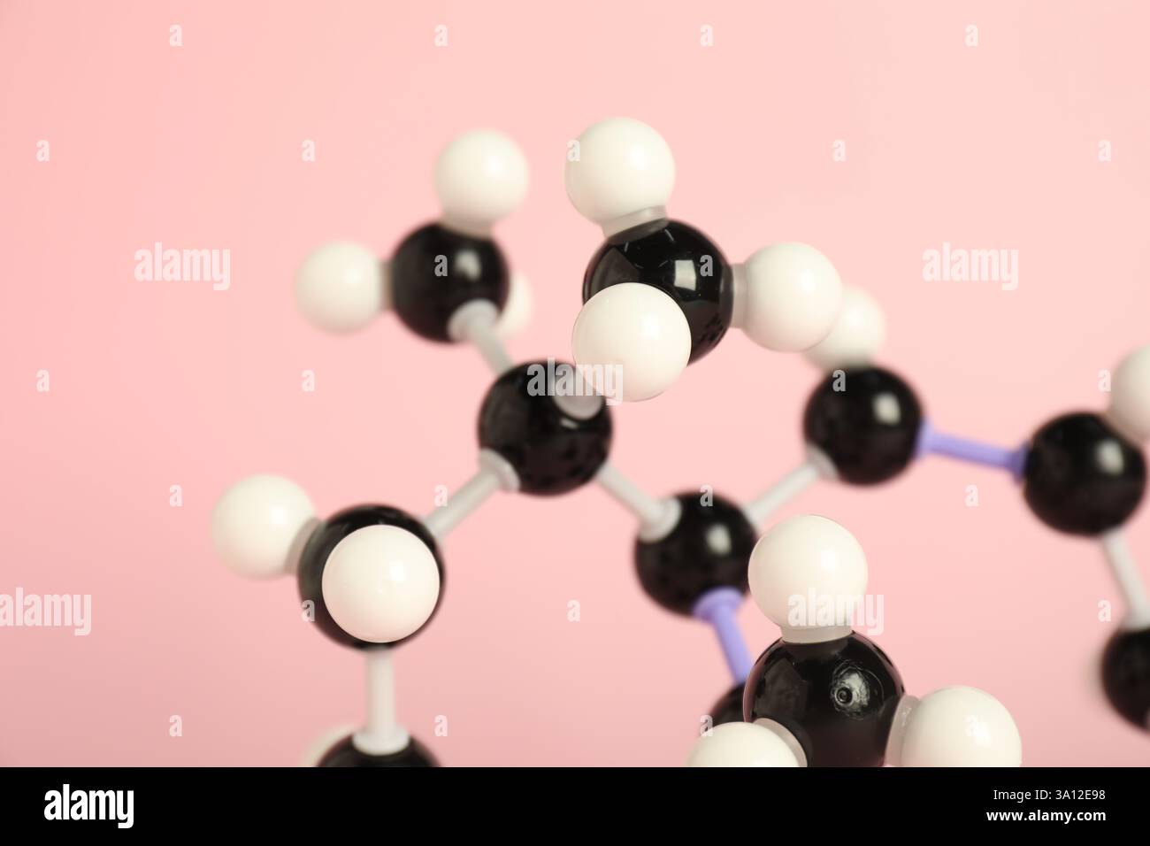 Molecule of retinol (vitamin A) on pink background, closeup. Chemical ...