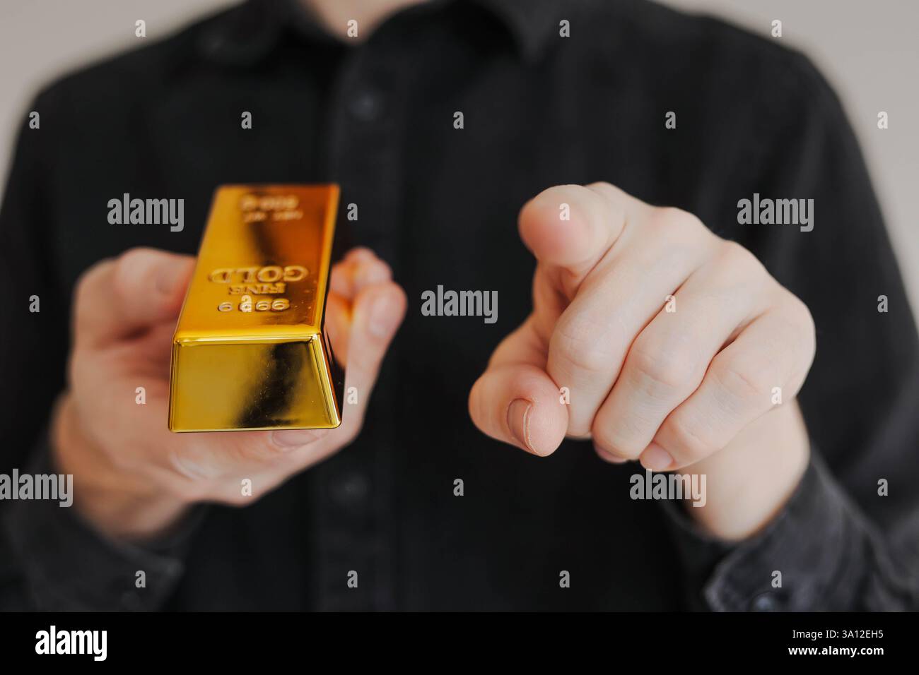 Man holds gold and pointing his finger to the camera close up. Gold is ...