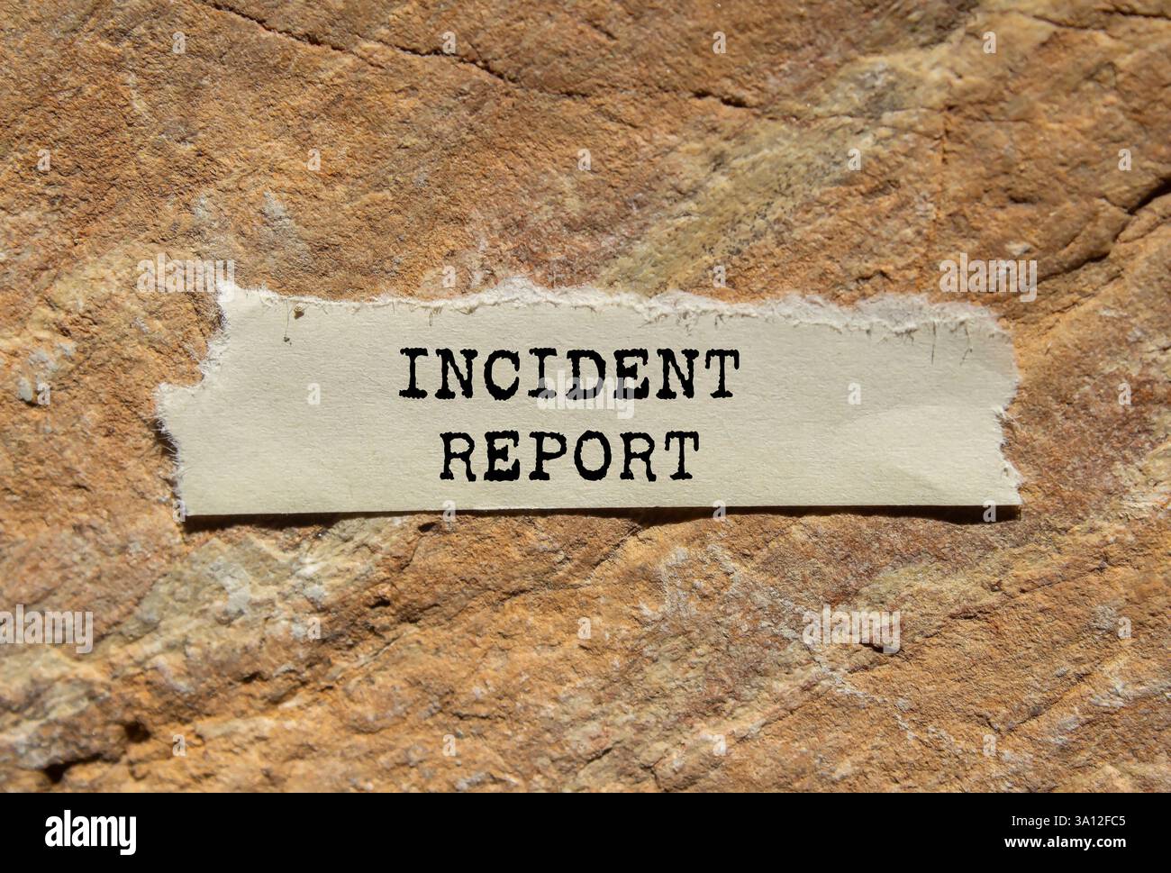 Incident report message written on ripped torn paper on stone background. Conceptual incident ...