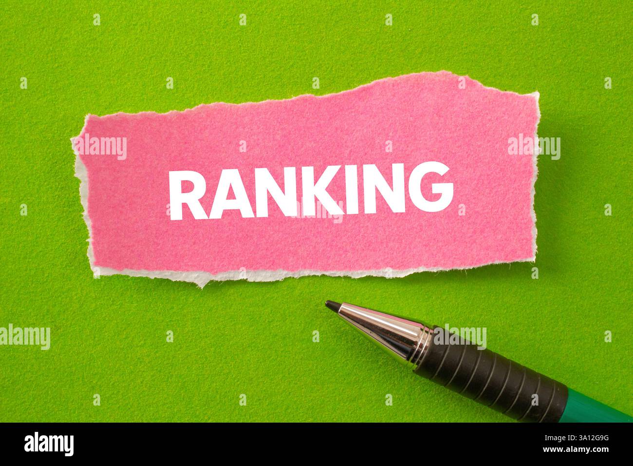 Ranking message written on ripped torn pink paper piece on green background. Conceptual ranking ...
