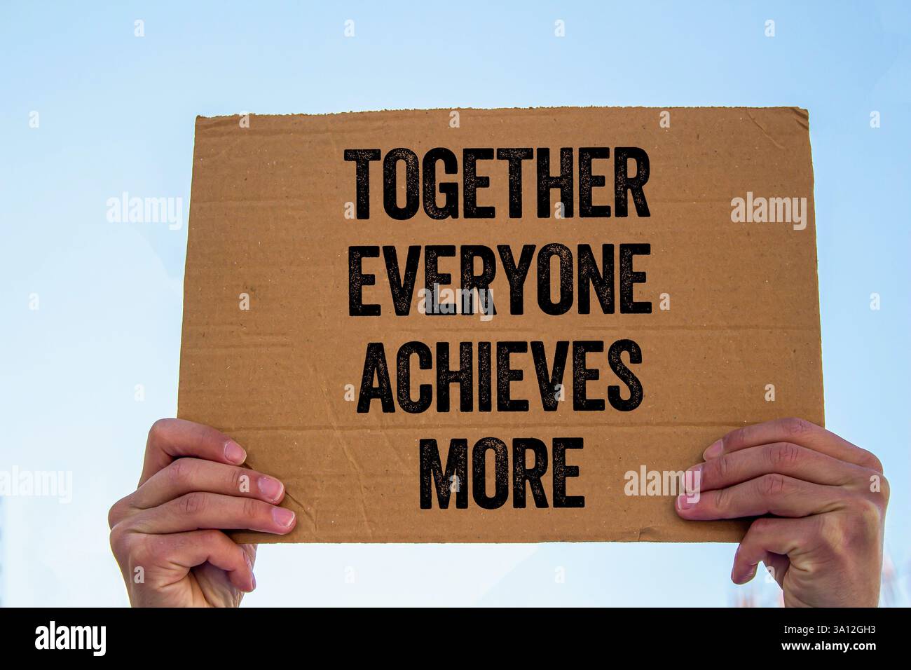 Together everyone achieves more message written on cardboard sign ...