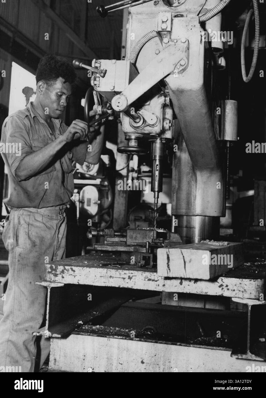 Native mechanic in Port Moresby Marine Workshop.Native boys are being ...