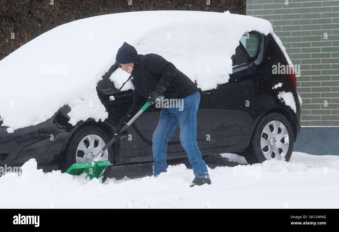 removing snow from the car, snow cleaning on a winter day removing snow ...