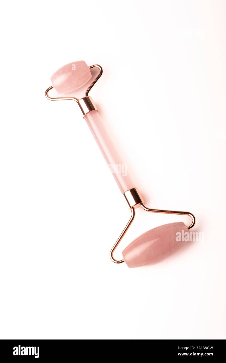 Rose pink face roller isolated on a white background Stock Photo - Alamy