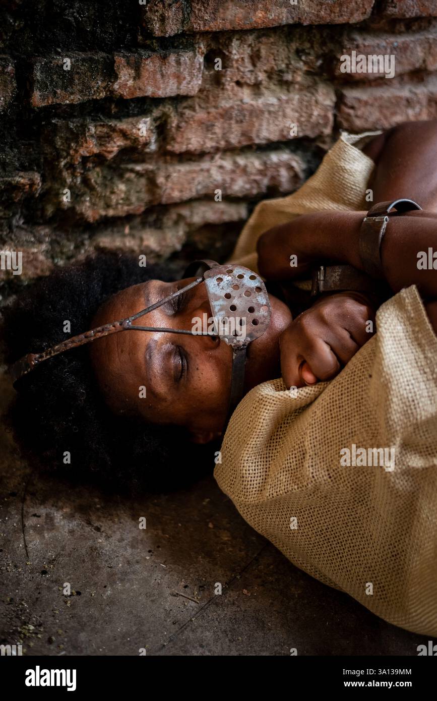 Portrait of a black woman chained and with an iron mask over her mouth ...
