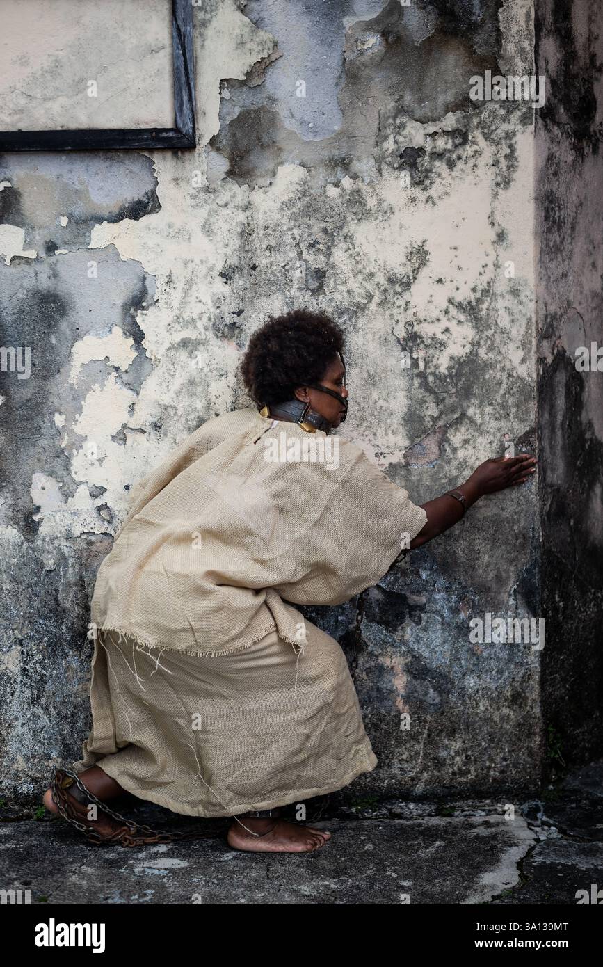 Portrait of a black woman in chains and with an iron mask on her head ...