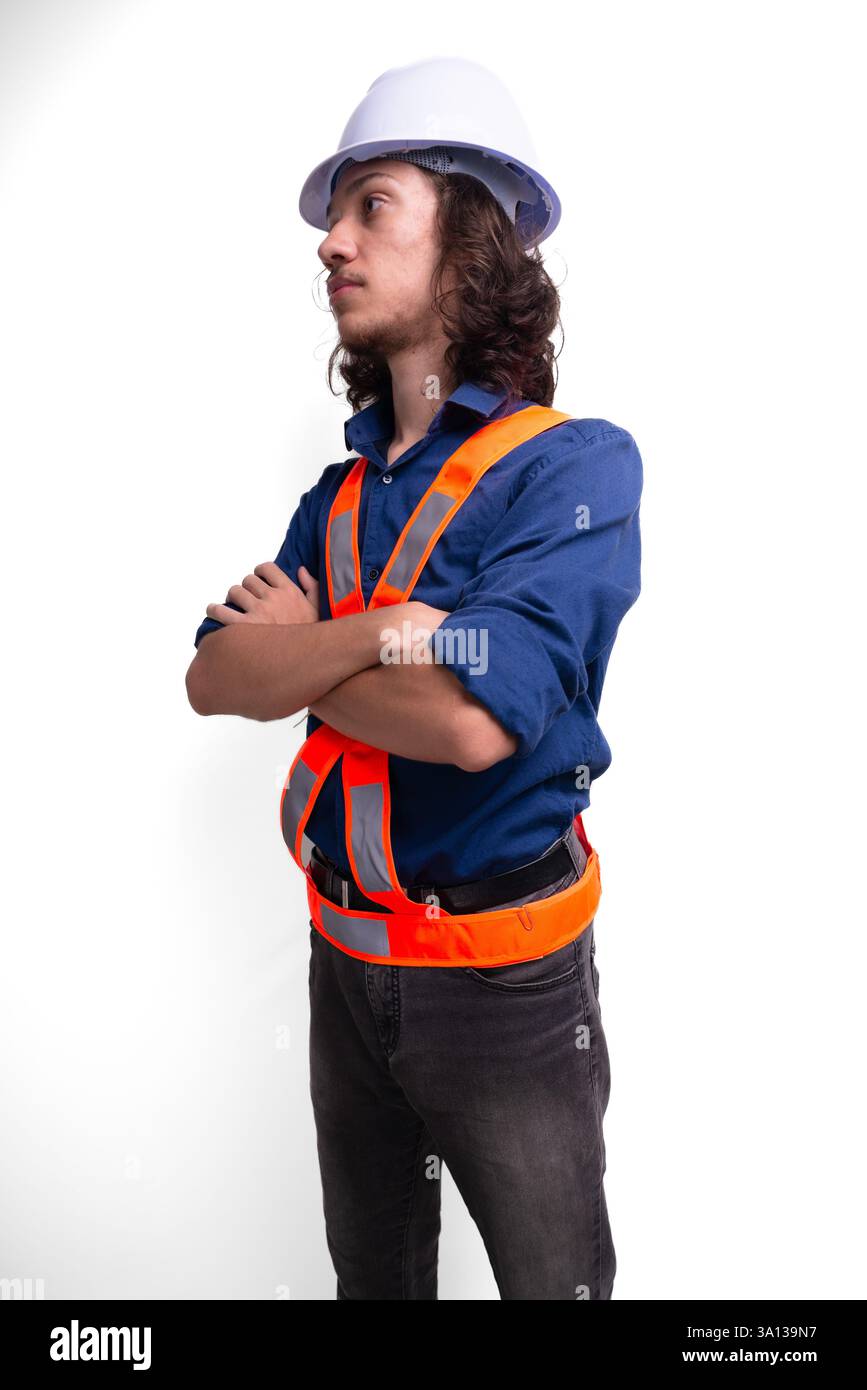 Young engineer wearing white helmet and luminous vest is posing for ...