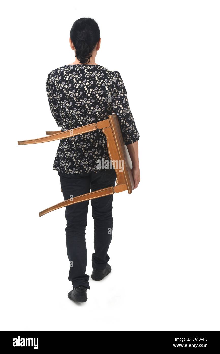 back view of a walking woman carrying old table on white background ...