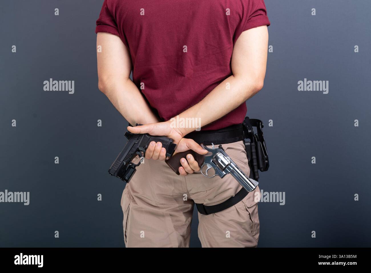 Shooting instructor, with his back to the camera, holding two guns ...