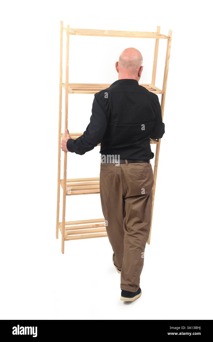 back view of a man walking carrying a wooden shelf on white background ...