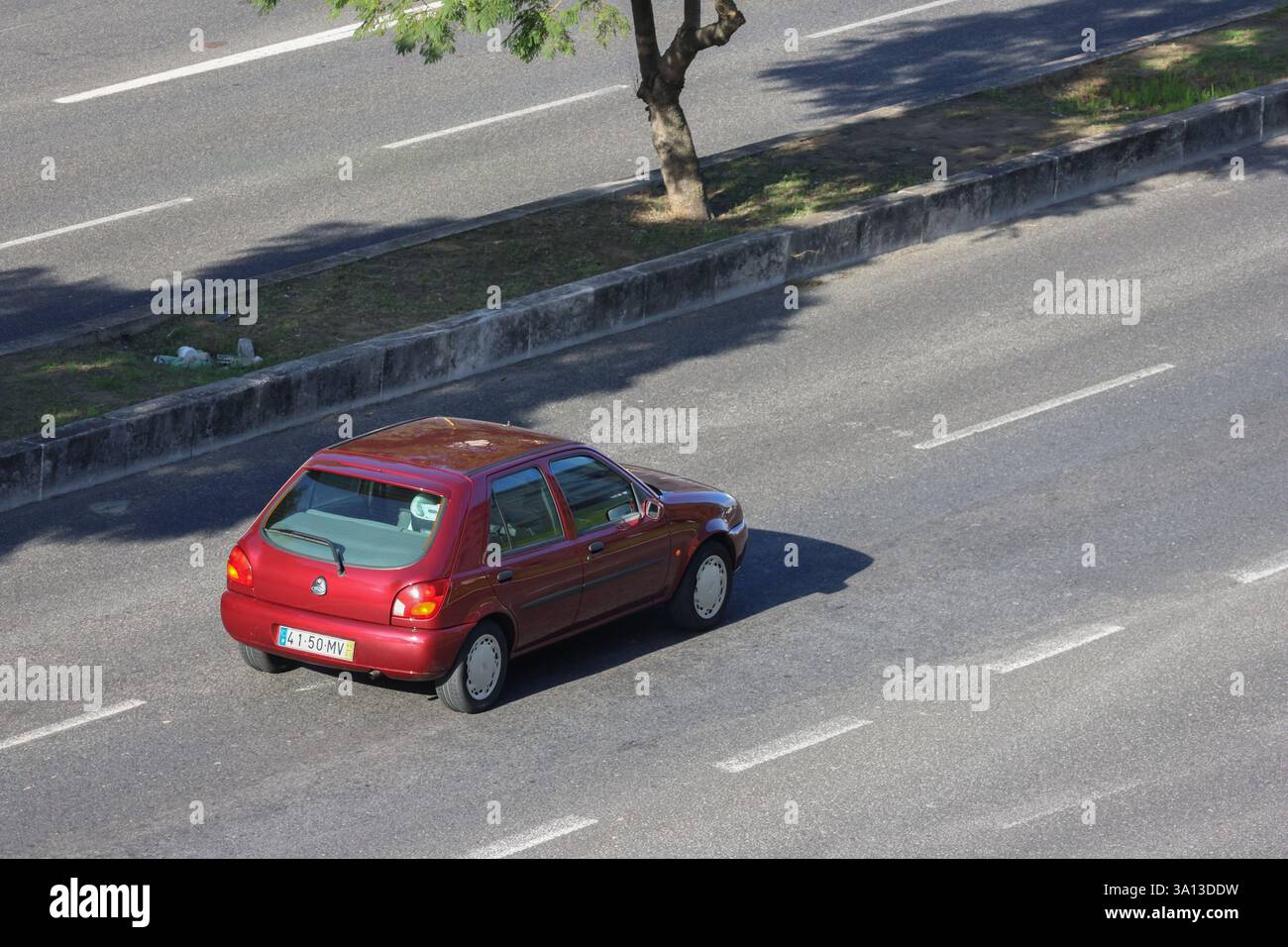 Red ford fiesta mk4 car driving on an asphalt road near a tree Stock ...
